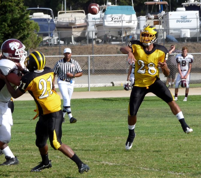 Photo: Mission Bay quarterback Dillon Baxter gets some air on a pass ...